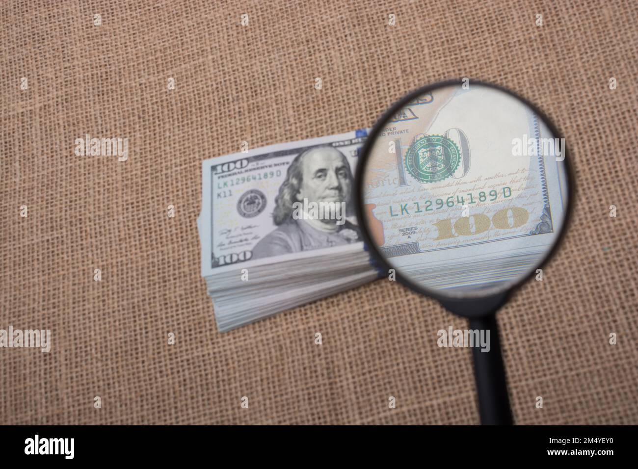 Magnifying glass over the banknote bundle of US dollar Stock Photo - Alamy