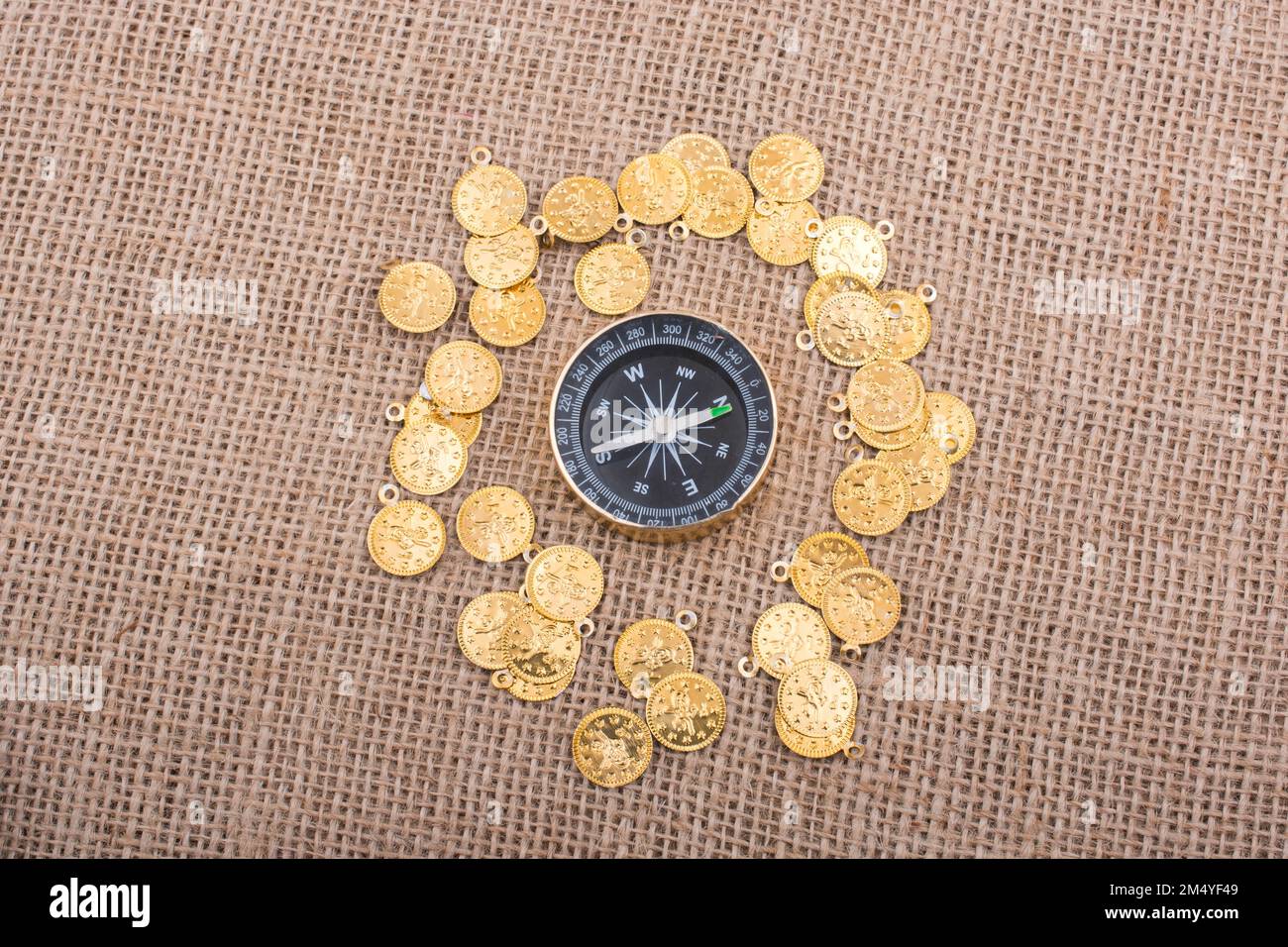 Fake golden coins around the compass instrument Stock Photo - Alamy