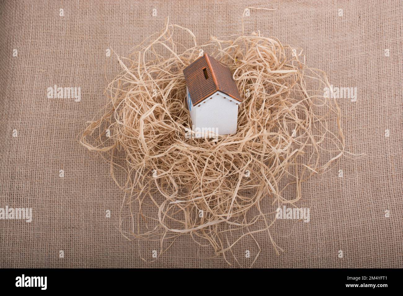 House placed on straw on canvas background Stock Photo - Alamy