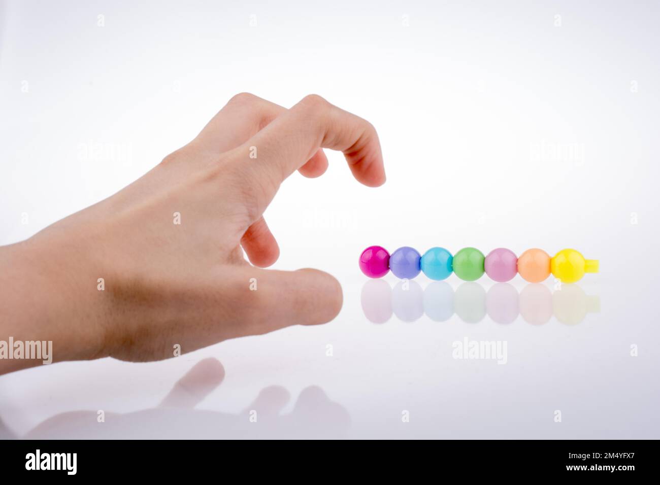 Hand frightning color beads with facial expression on white background ...