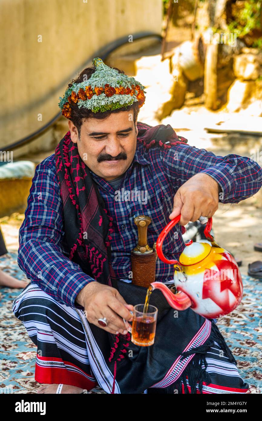 Traditional dressed man of the Qahtani Flower men tribe, serving tee ...
