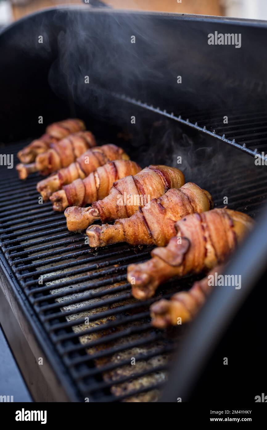 A grill with chicken legs wrapped in bacon Stock Photo - Alamy