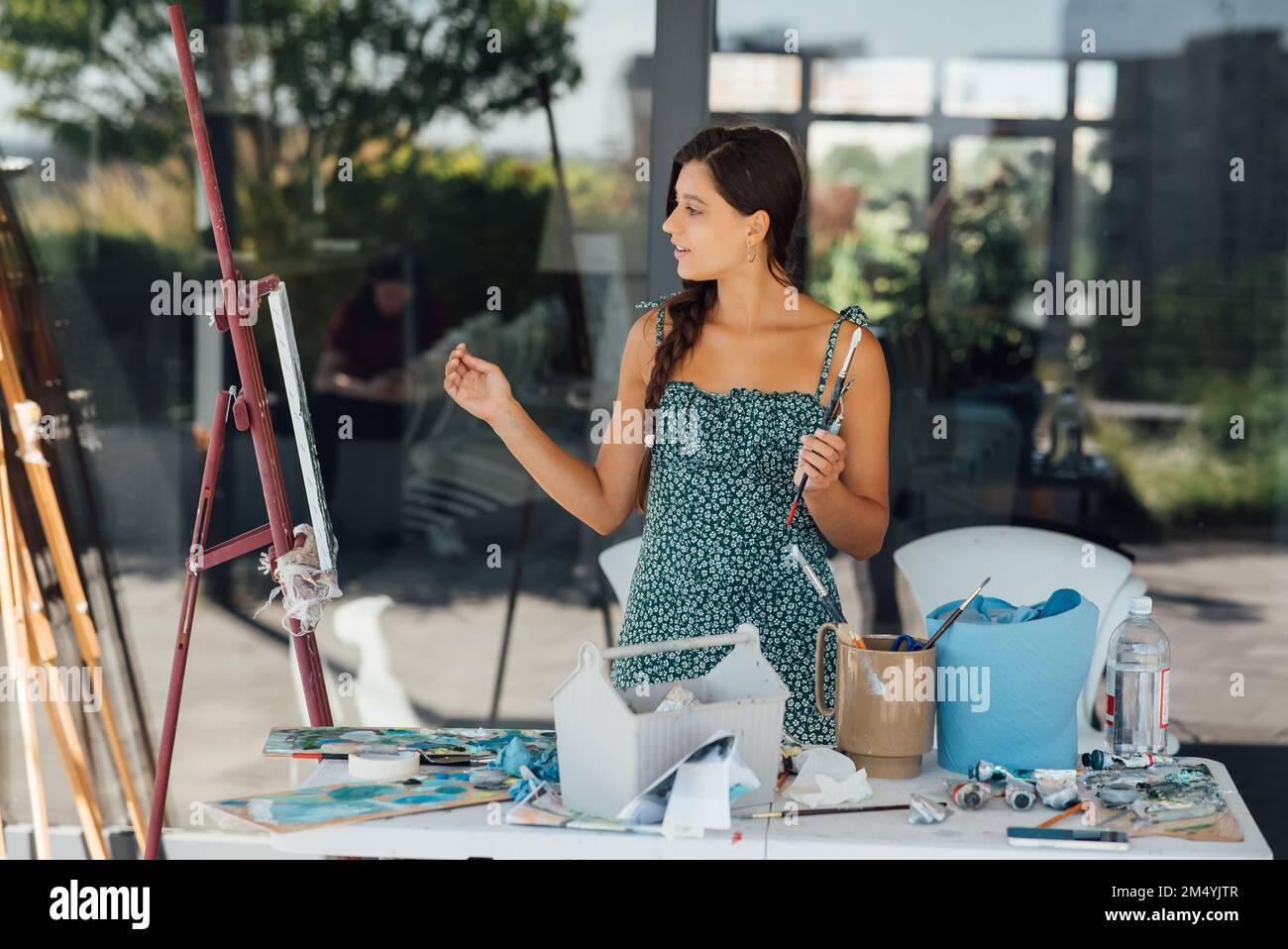 Young beautiful female artist with tools posing for camera Stock Photo ...