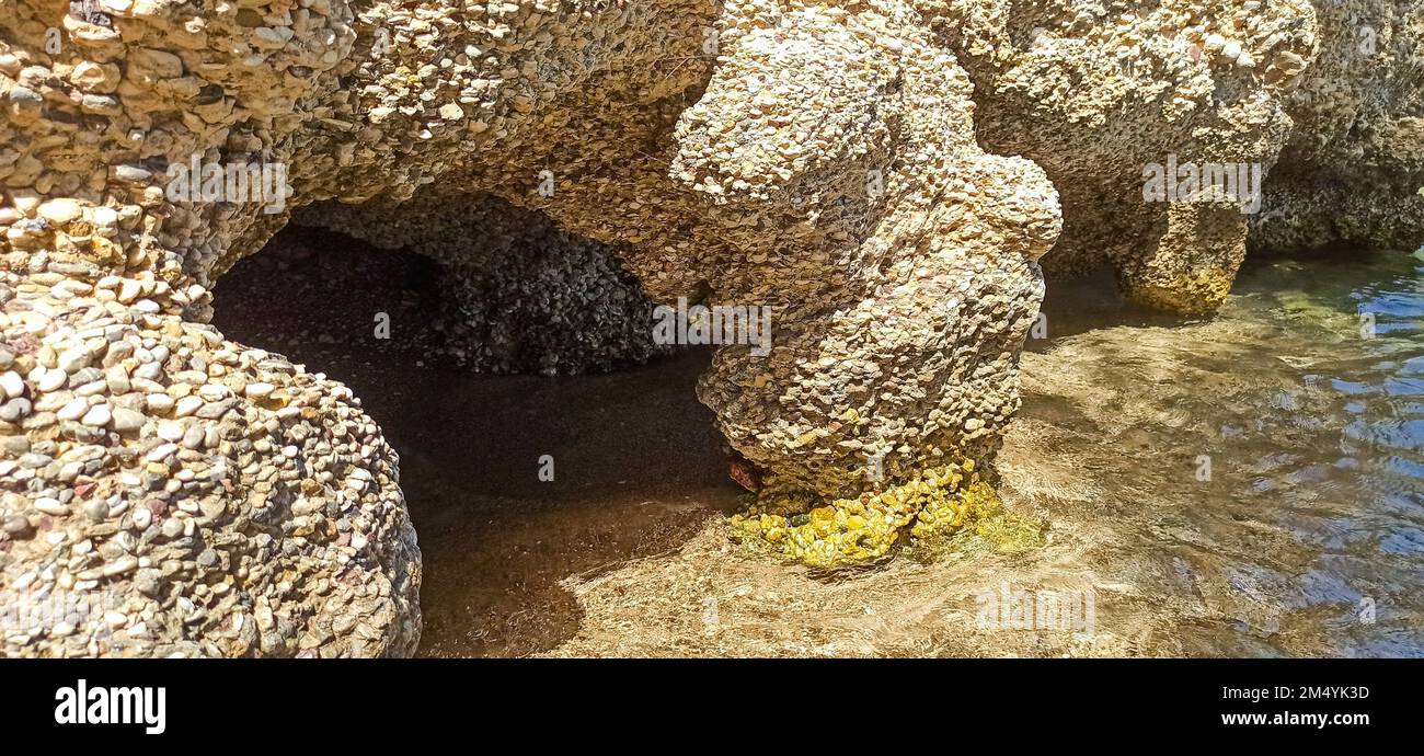 A panoramic view of beautiful caves on the shore of a beach in Paleo ...