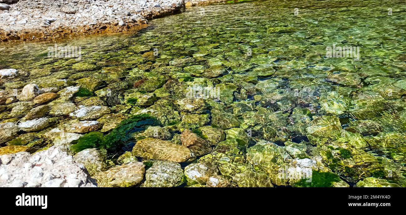 A panoramic shot of rocks in the crystal clear water at the beach in ...