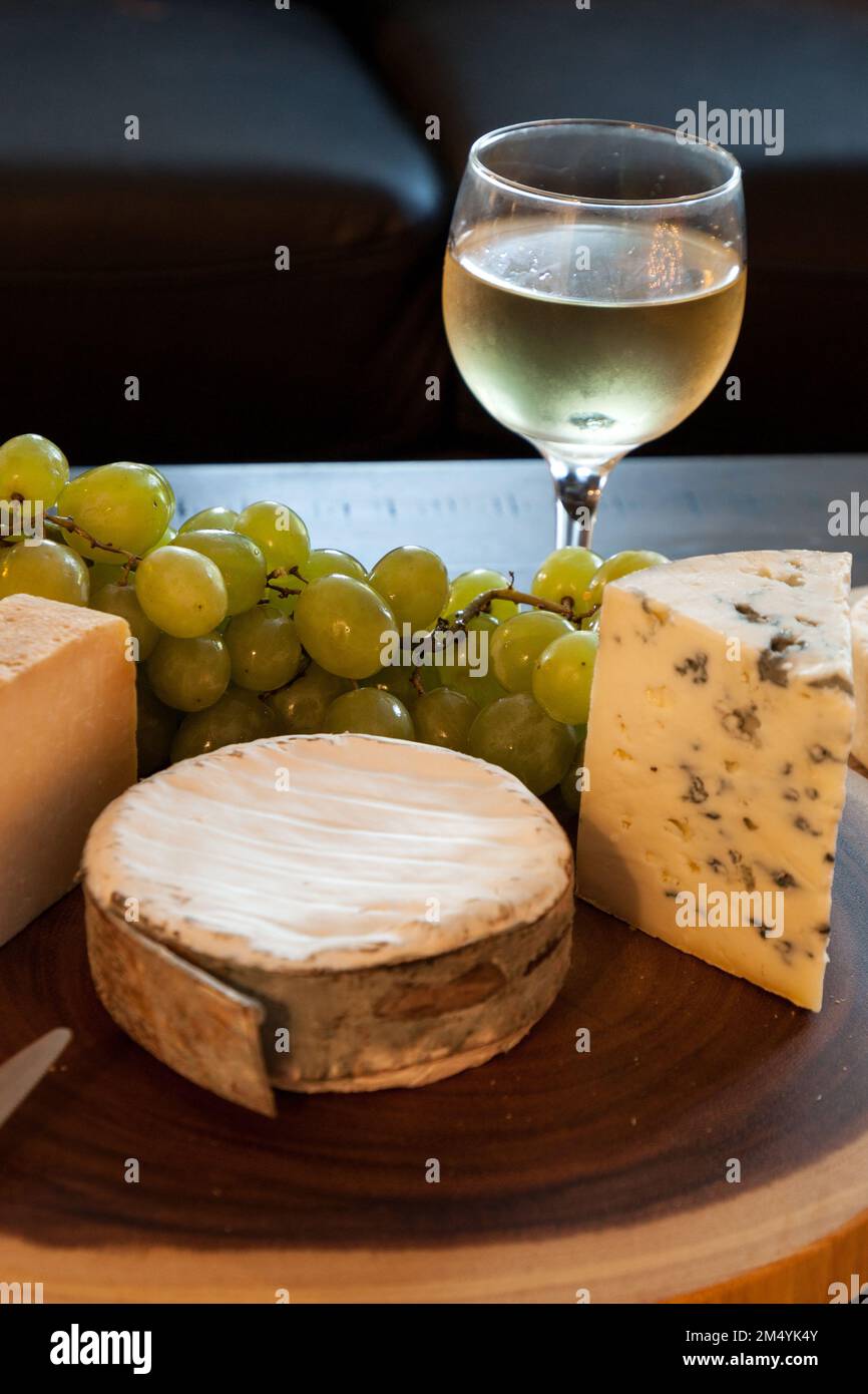 Cheese plate and wine including chardonnay, gourmet crackers, a washed ...