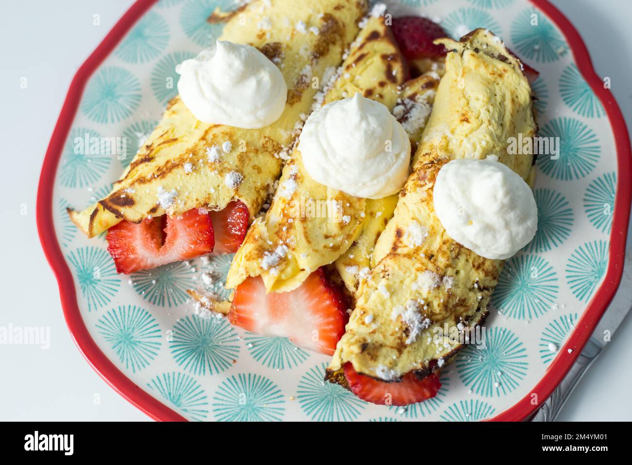 A plate with strawberry crepes with whipped cream topping Stock Photo ...