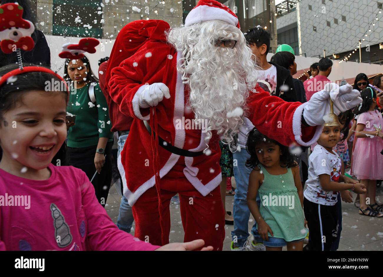 Mumbai, India. 23rd Dec, 2022. A man dressed as Santa Claus interacts ...