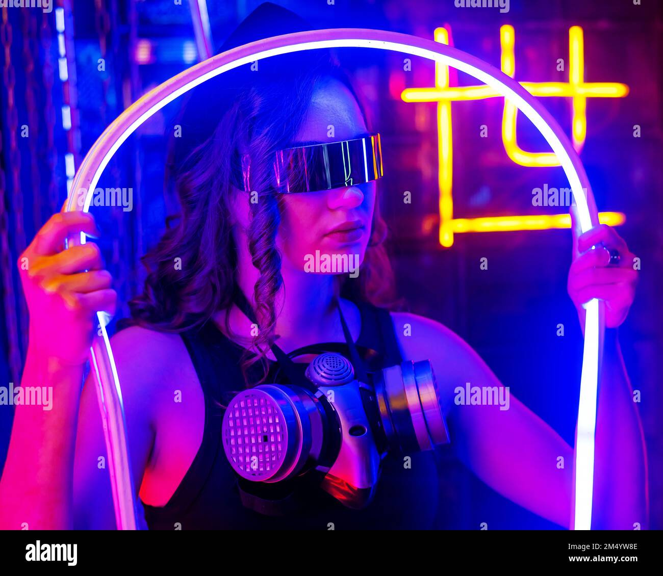 Caucasian woman in sunglasses posing in neon studio Stock Photo - Alamy