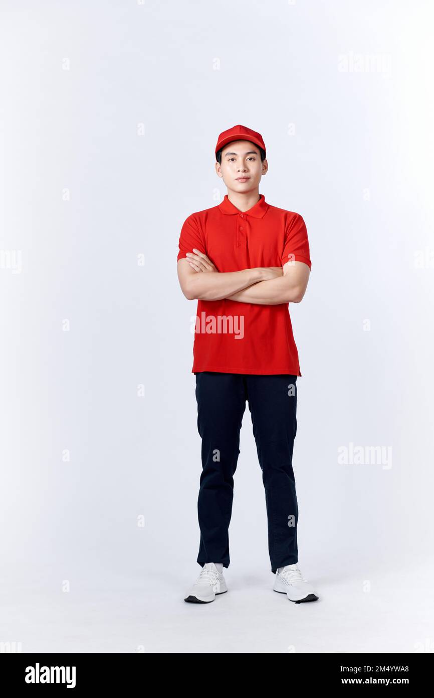 Smiling friendly-looking asian delivery guy in blue uniform cross arms ...