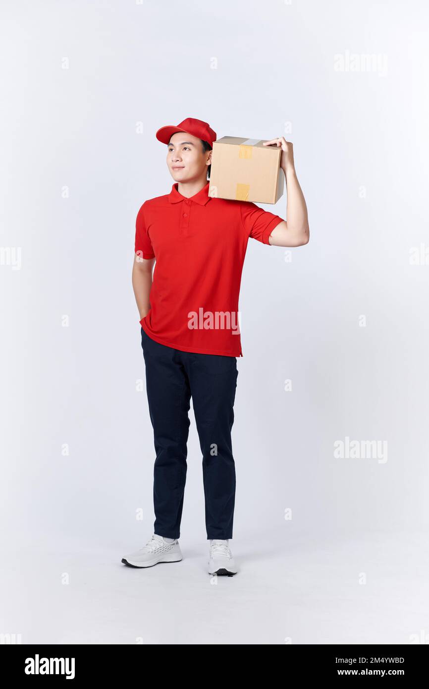 Work at post office. Courier in red uniform holding big parcel, free ...