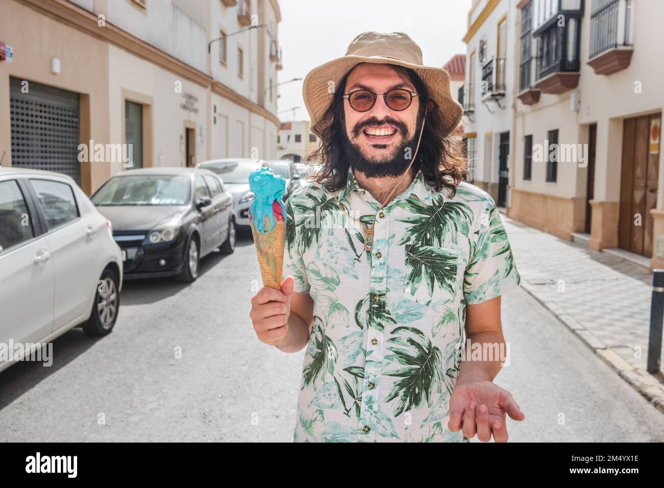 A happy Caucasian man with long hair and a beard holding a blue ice ...