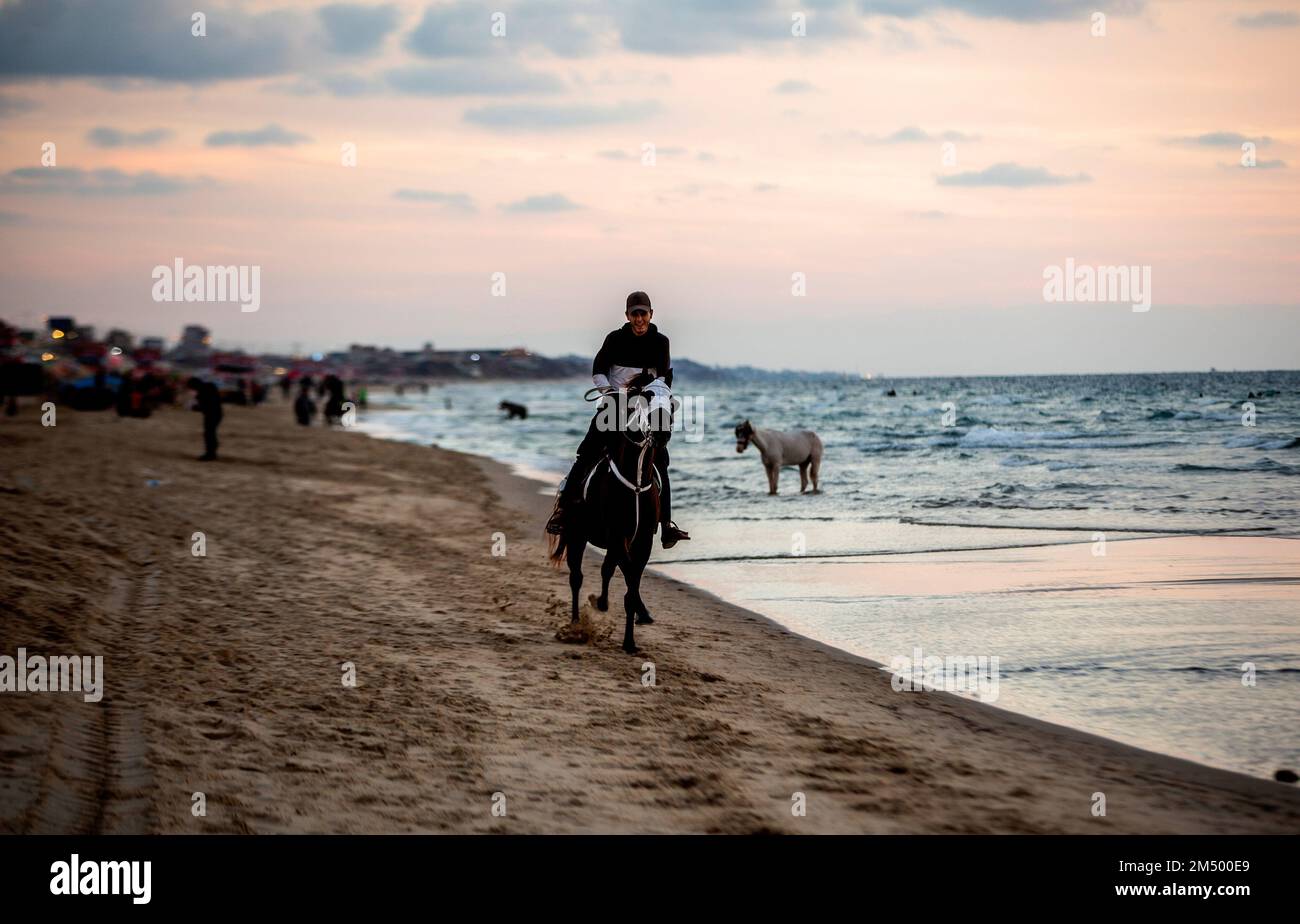 Gaza, Palestine. 24th Dec, 2022. A Palestinian rides his horse on the ...