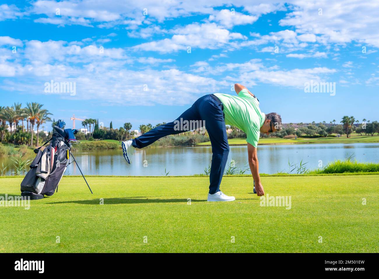 A scenic view of a Caucasian man playing a golf match on a bright sunny ...