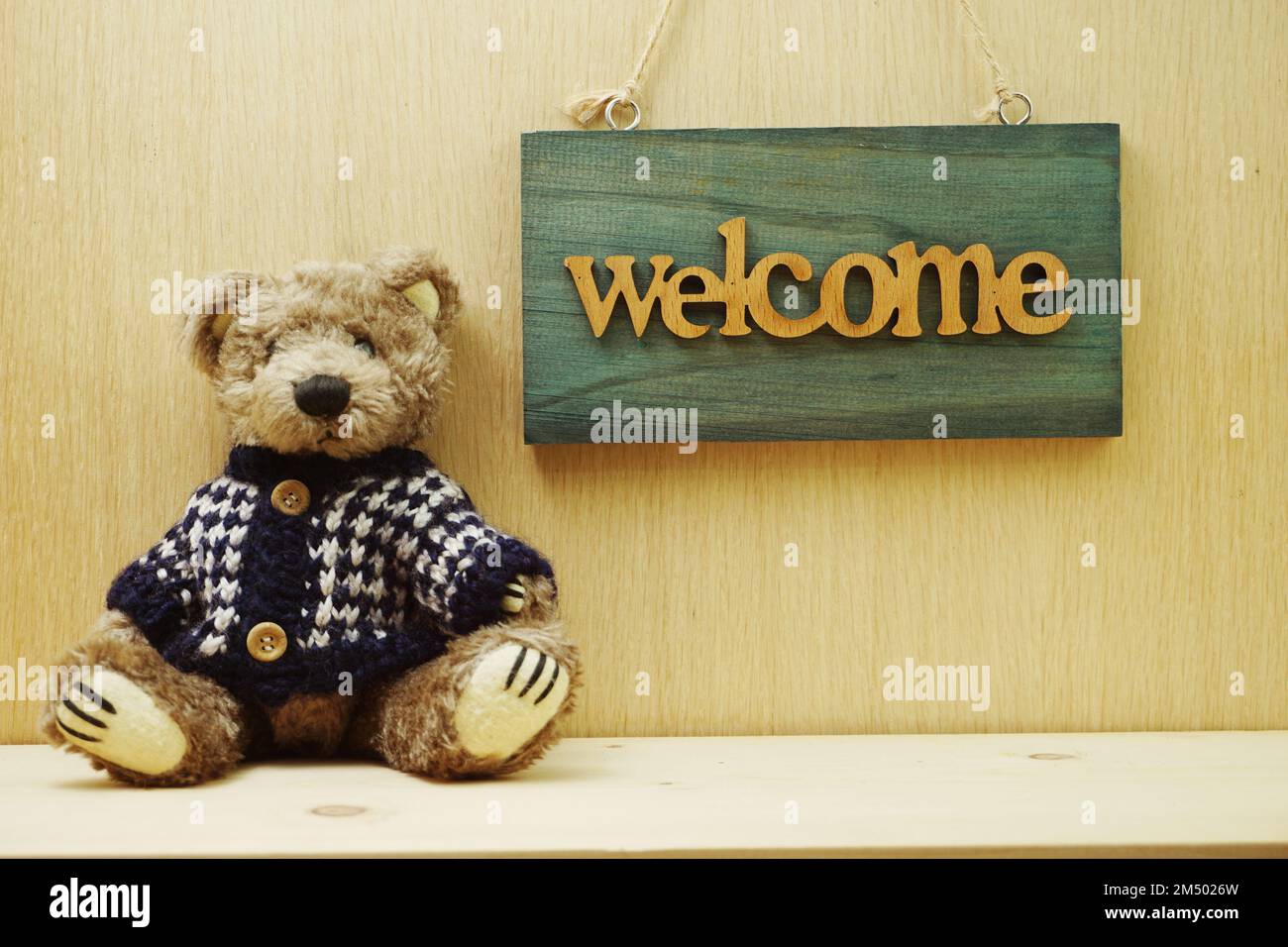 Welcome Sign and Teddy bear on wooden background Stock Photo - Alamy