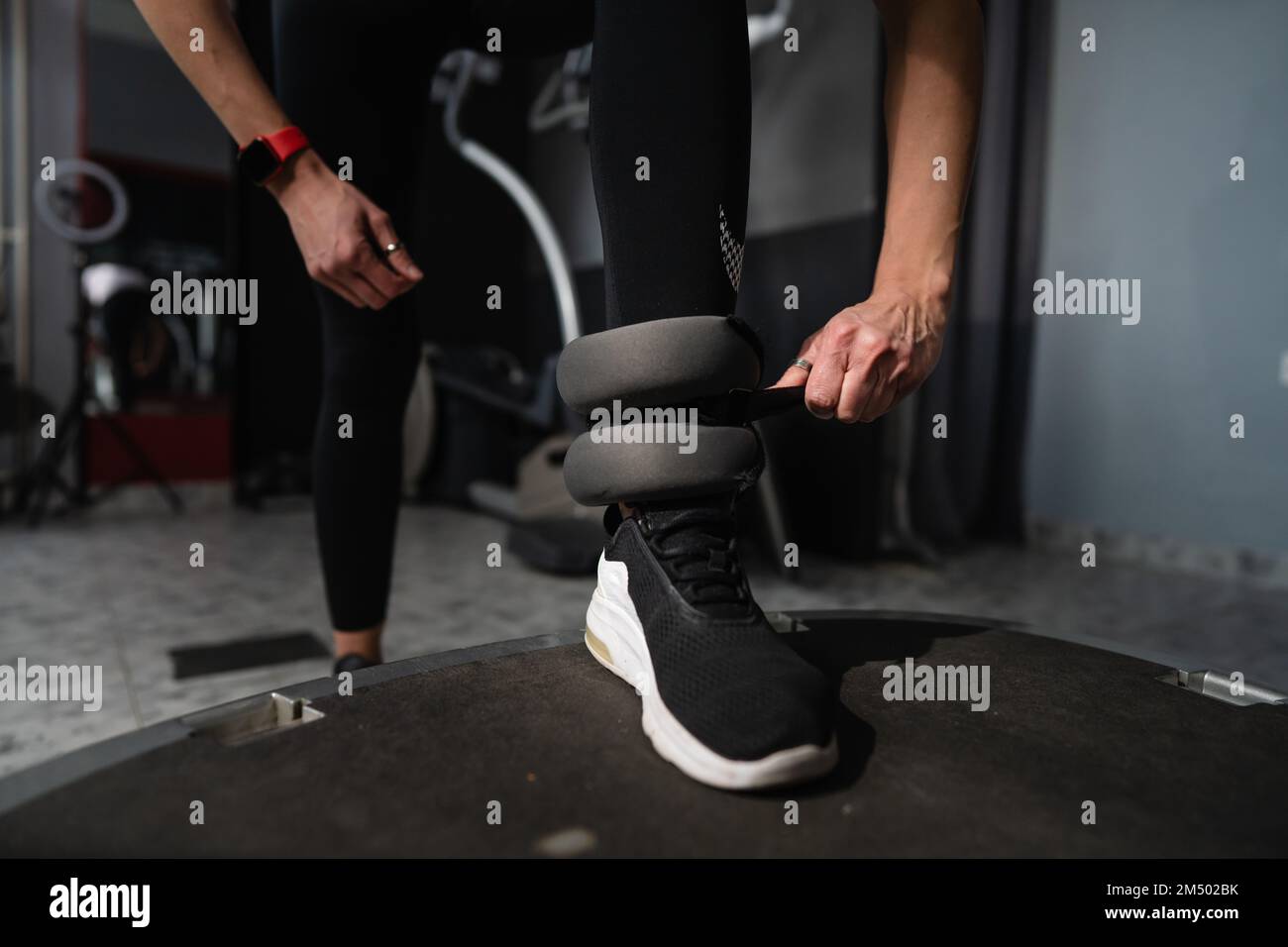Close up on foot of unknown caucasian woman putting ankle weight on the ...