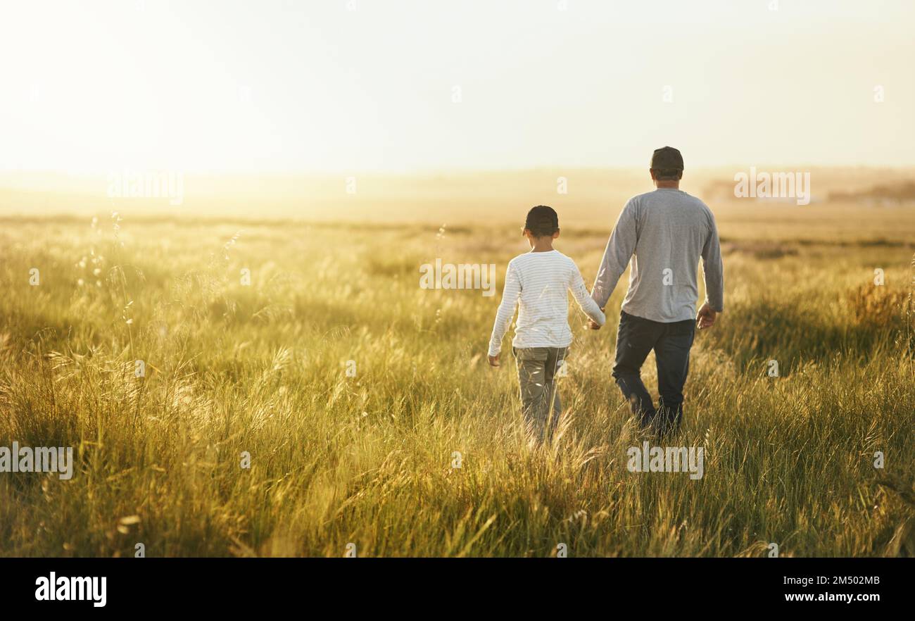 Theres beauty in simplicity. a man taking his son for a walk out on an ...