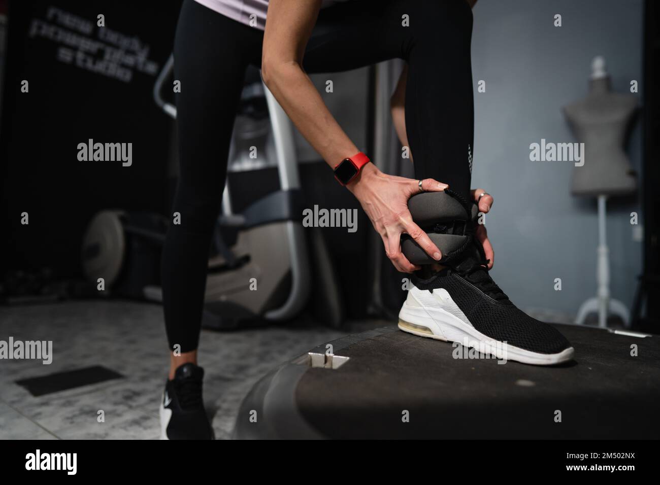 Close up on foot of unknown caucasian woman putting ankle weight on the ...