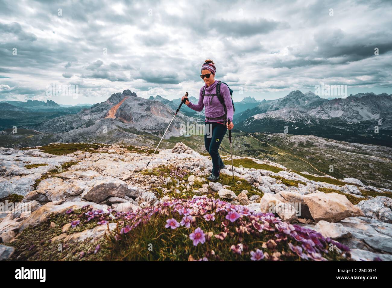 A young Caucasian woman hiking in the mountains of Seekofel, Dolomites ...