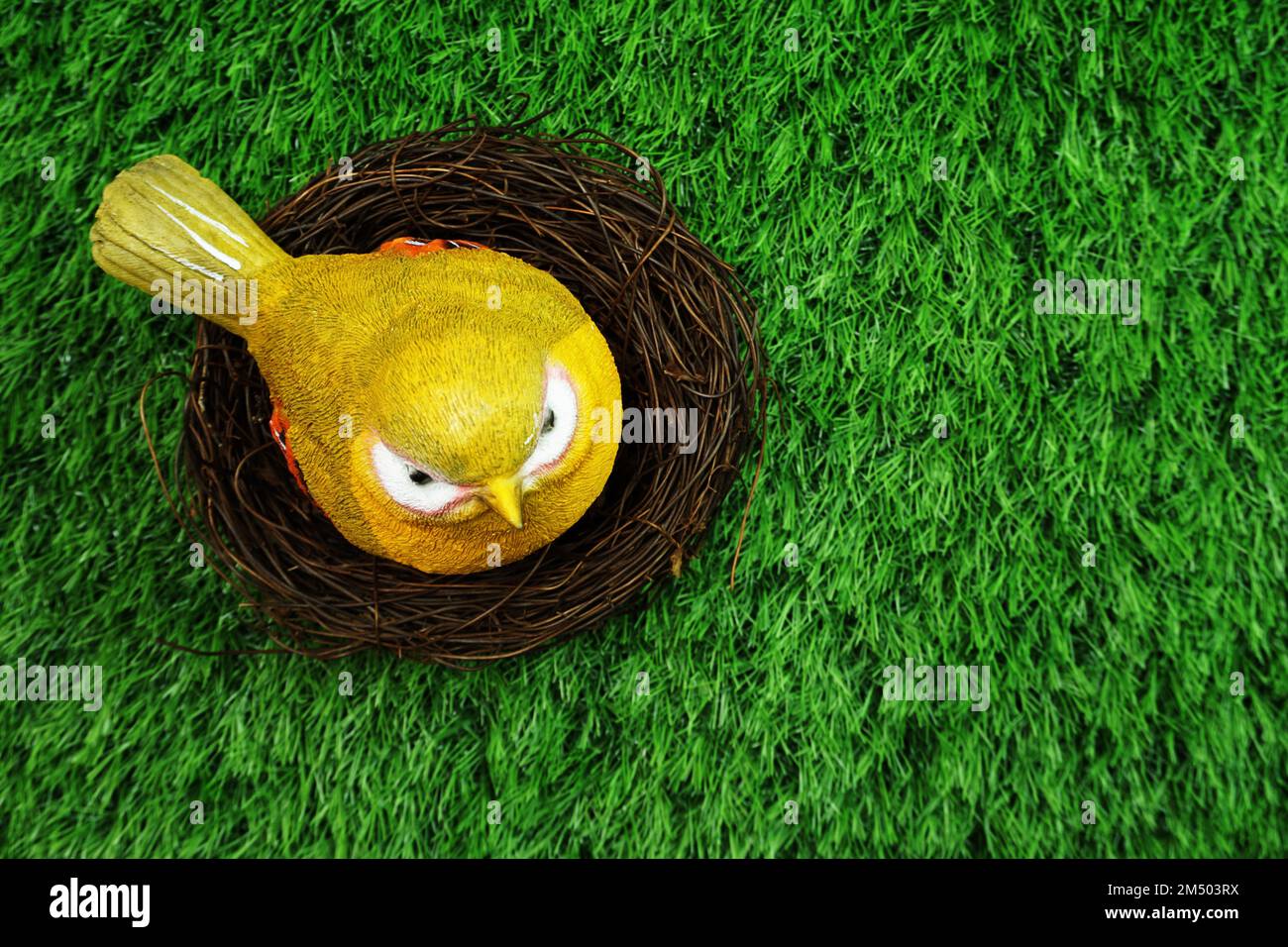 colorful bird statue with nest on artificial green grass Stock Photo ...
