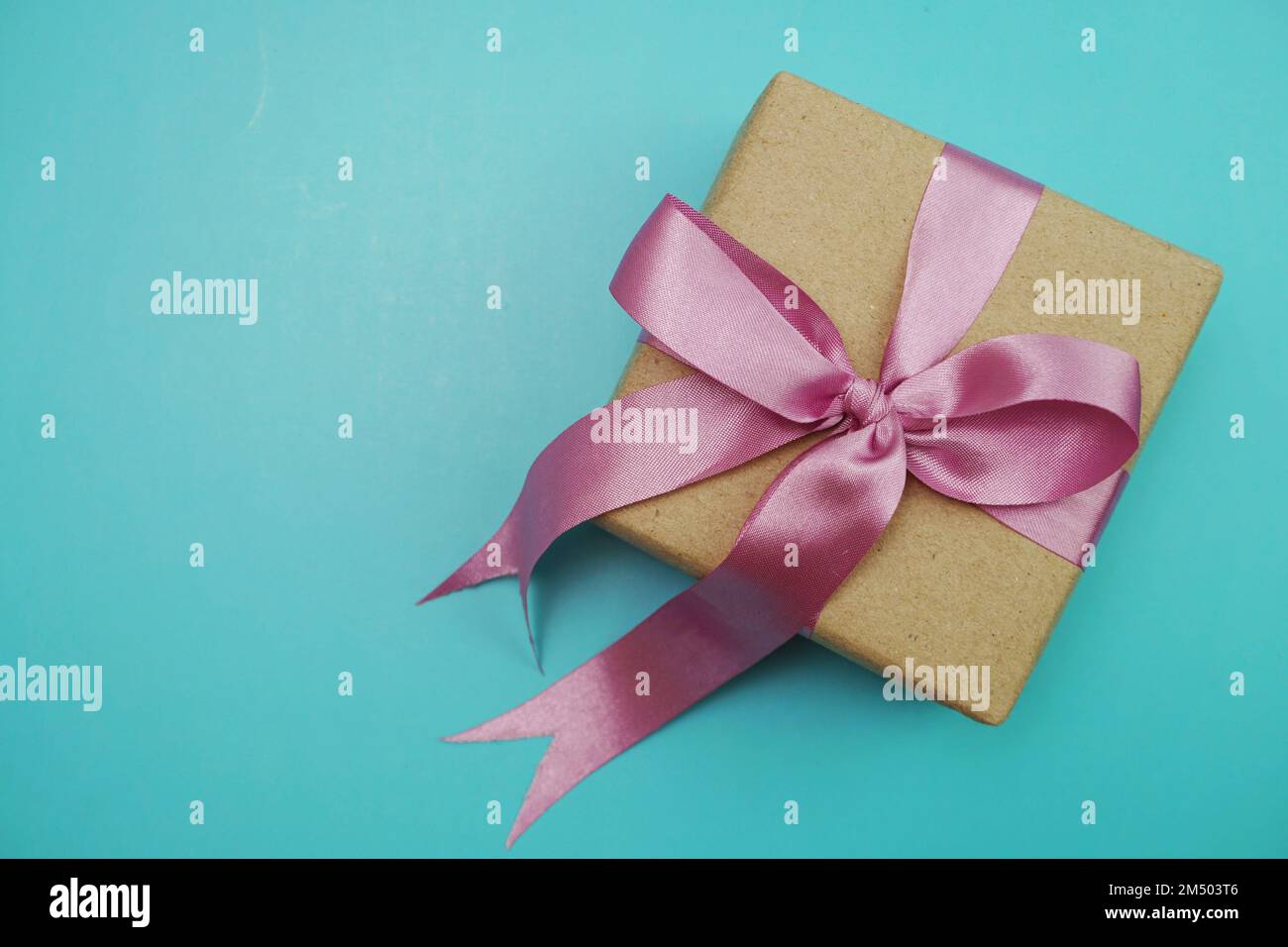 Gift box with pink bow ribbon on blue background Stock Photo - Alamy