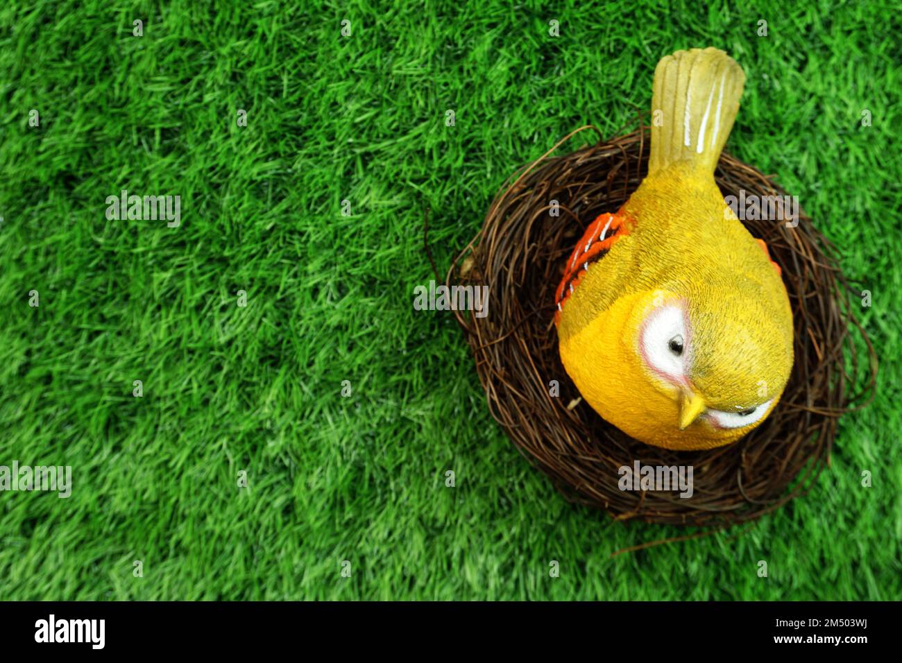 colorful bird statue with nest on artificial green grass Stock Photo ...