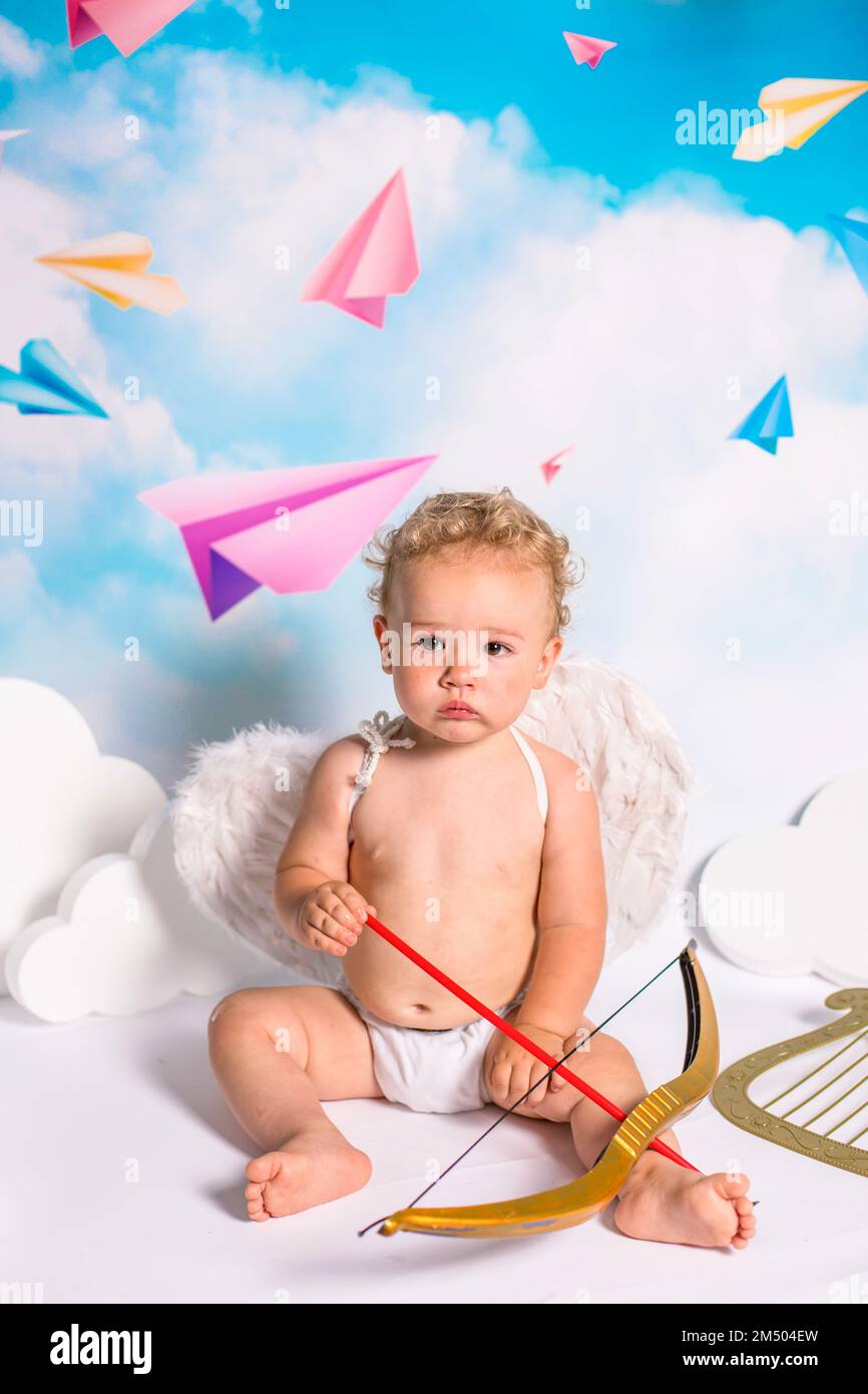 angel child is sitting the clouds looks down Stock Photo - Alamy