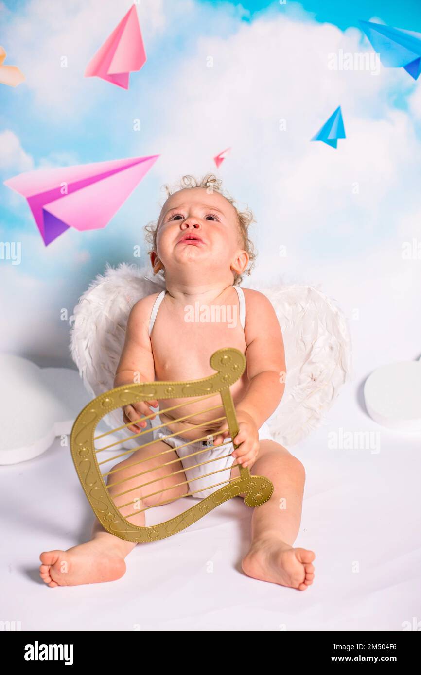 angel child is sitting the clouds looks down Stock Photo - Alamy