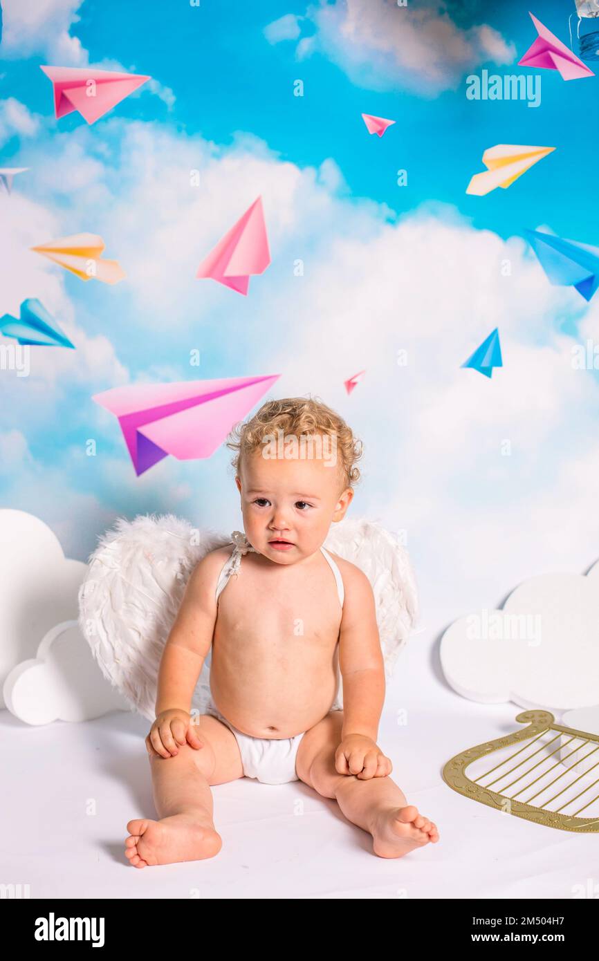 angel child is sitting the clouds looks down Stock Photo - Alamy
