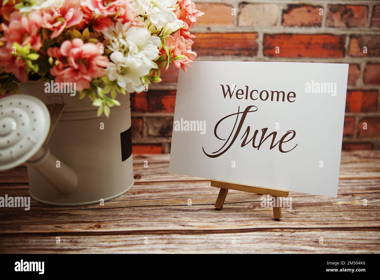 Welcome June text with flower bouquet decoration on wooden and old ...