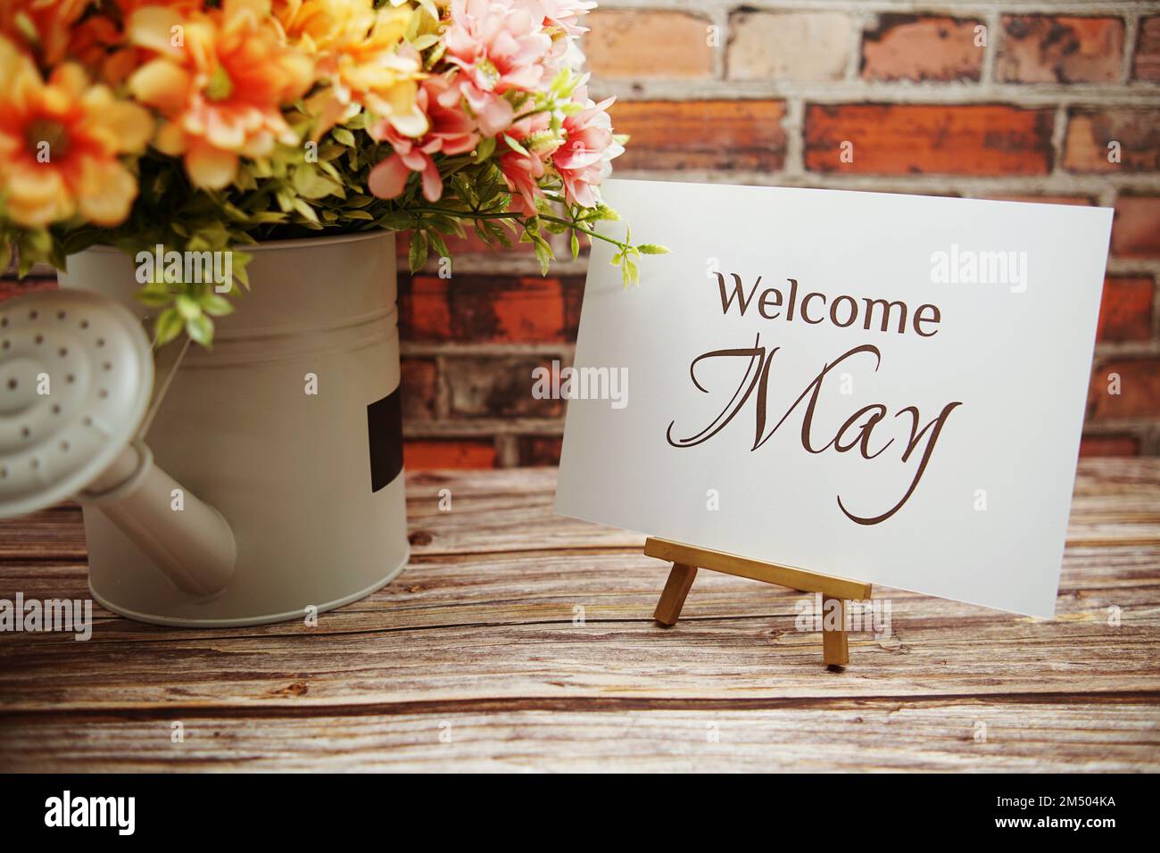 Welcome May text with flower bouquet decoration on wooden and old brick ...