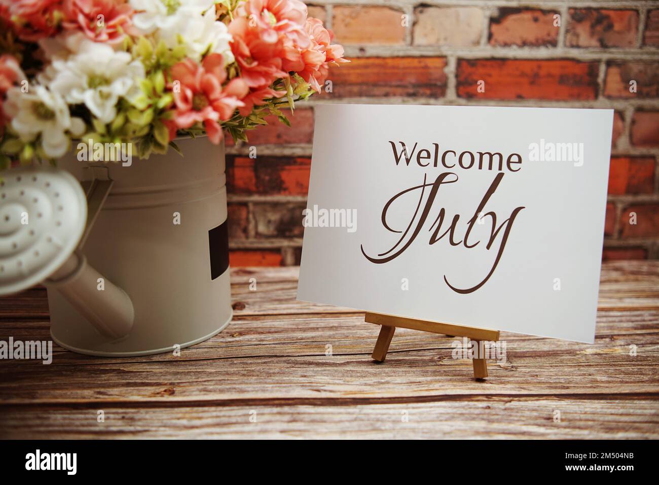 Welcome July text with flower bouquet decoration on wooden and old ...
