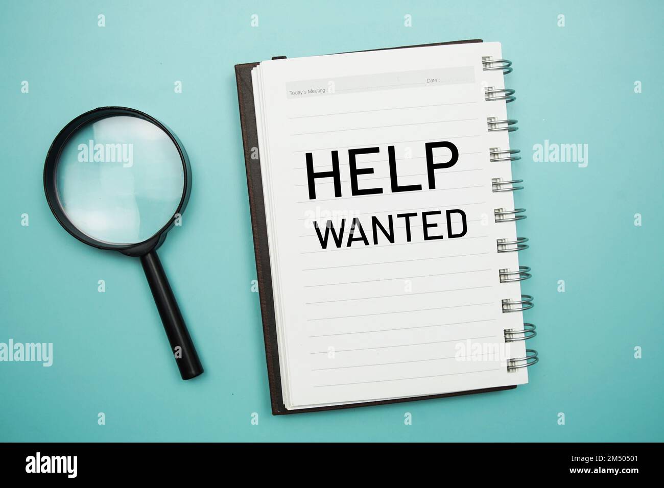 Help Wanted text on notepad and magnifying glass on blue background ...