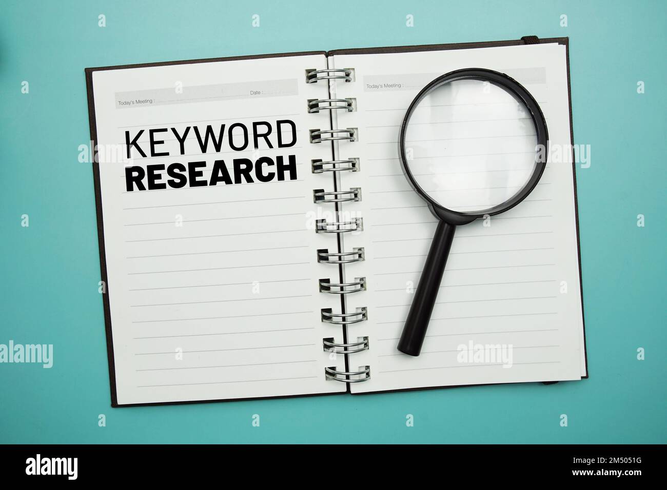 Keyword Research text on notepad and magnifying glass on blue ...