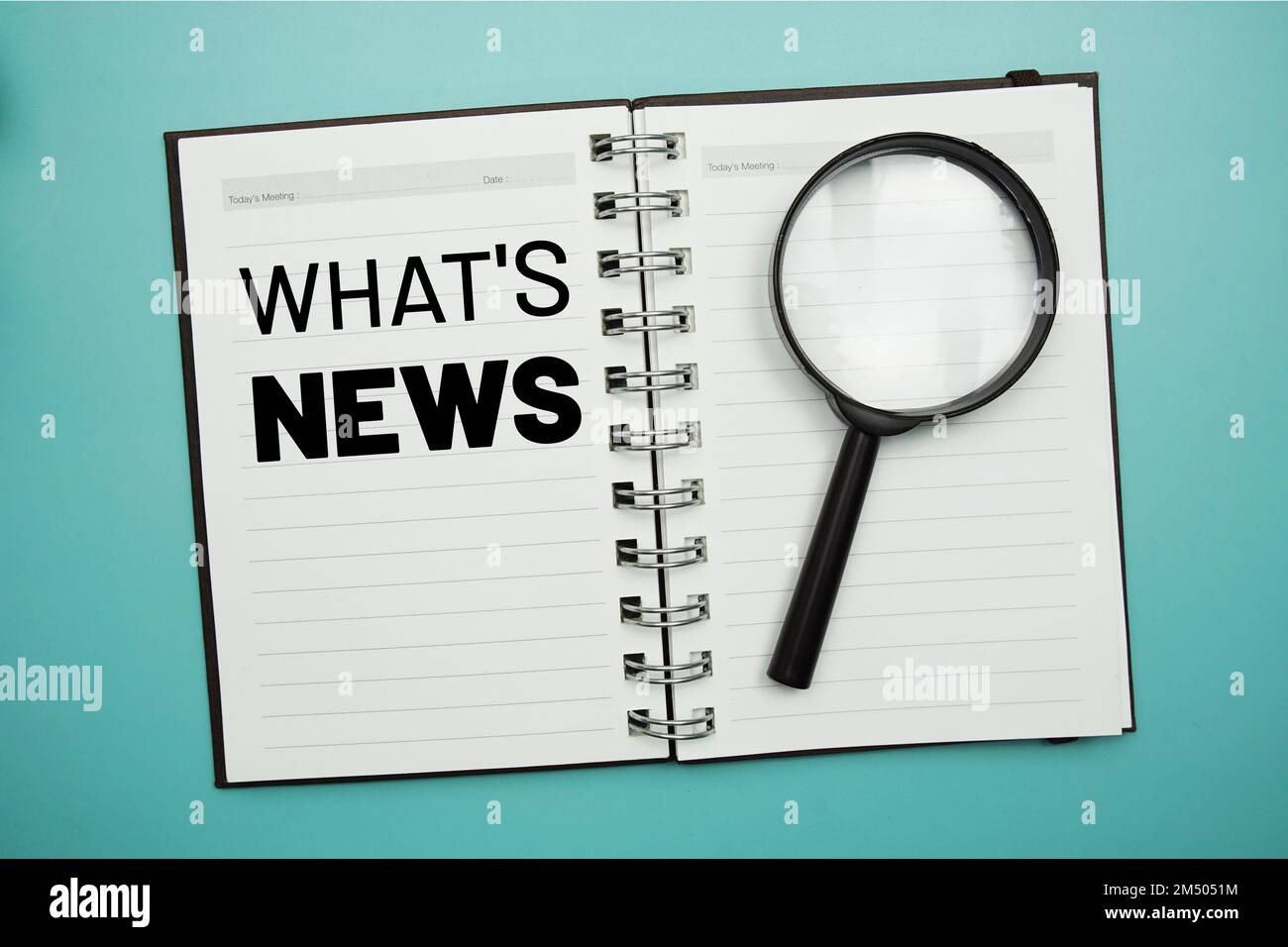Whats News text on notepad and magnifying glass on blue background ...