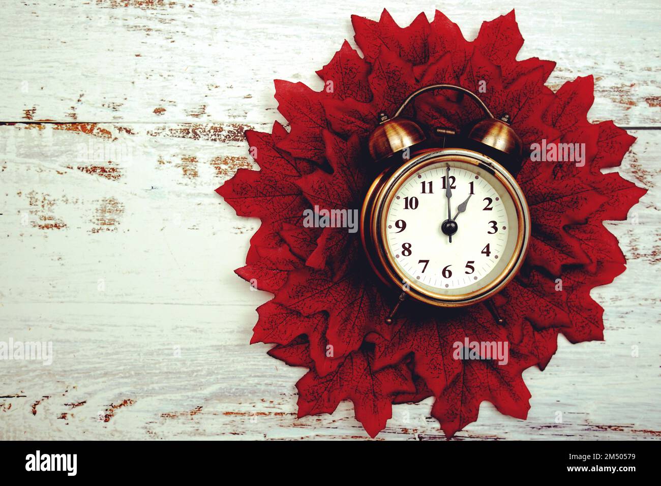 Alarm clock with maple leaves on wooden background Stock Photo - Alamy