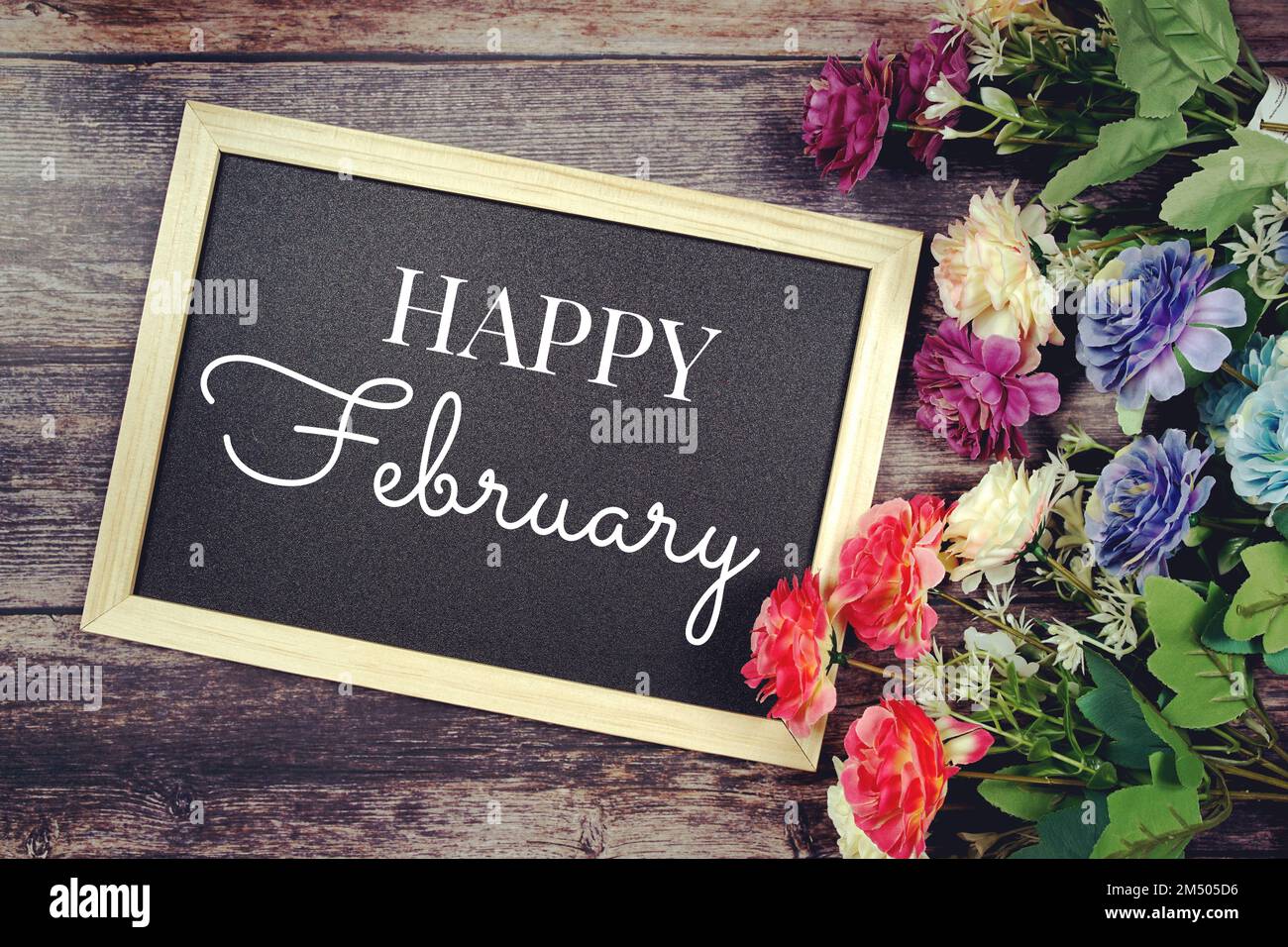 Happy February typography text and flower decoration on blackboard ...