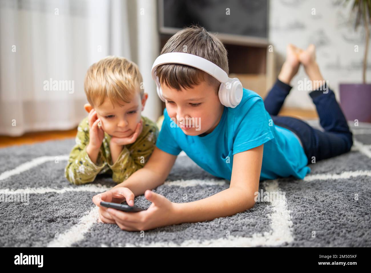 Two children watching smart phone, happy kids using smartphones ...