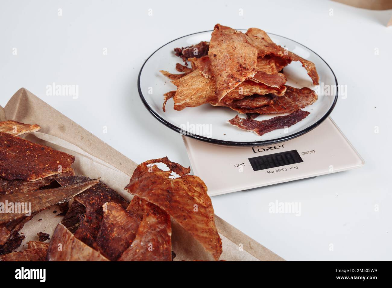 a guy puts dried meat in paper boxes in black gloves. High quality ...
