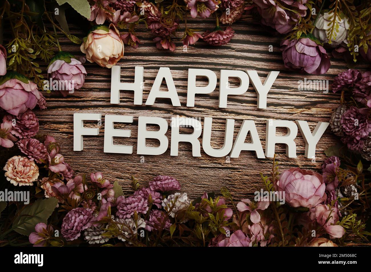 Happy February alphabet letters with flowers frame on wooden background ...