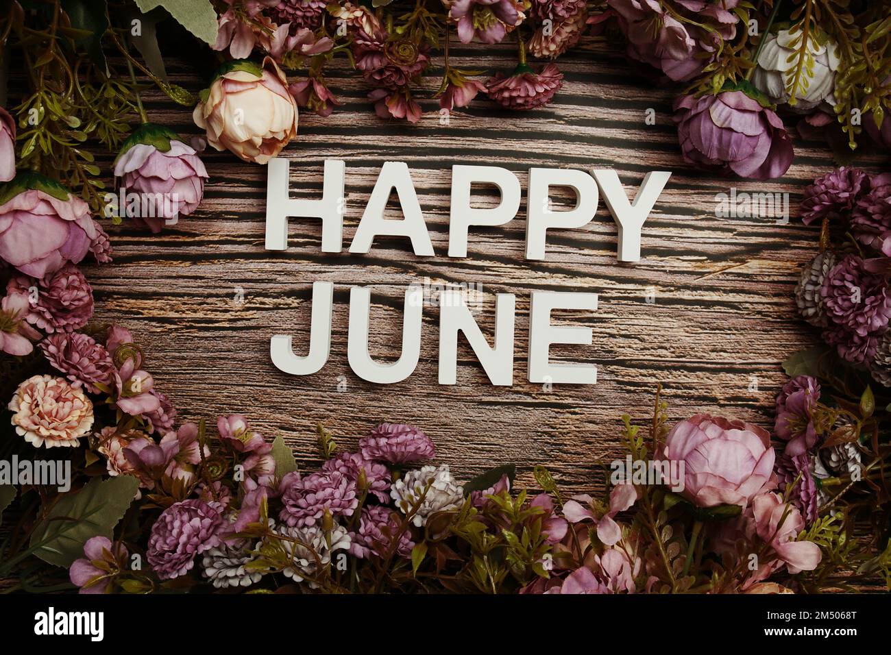 Happy June alphabet letters with flowers frame on wooden background ...
