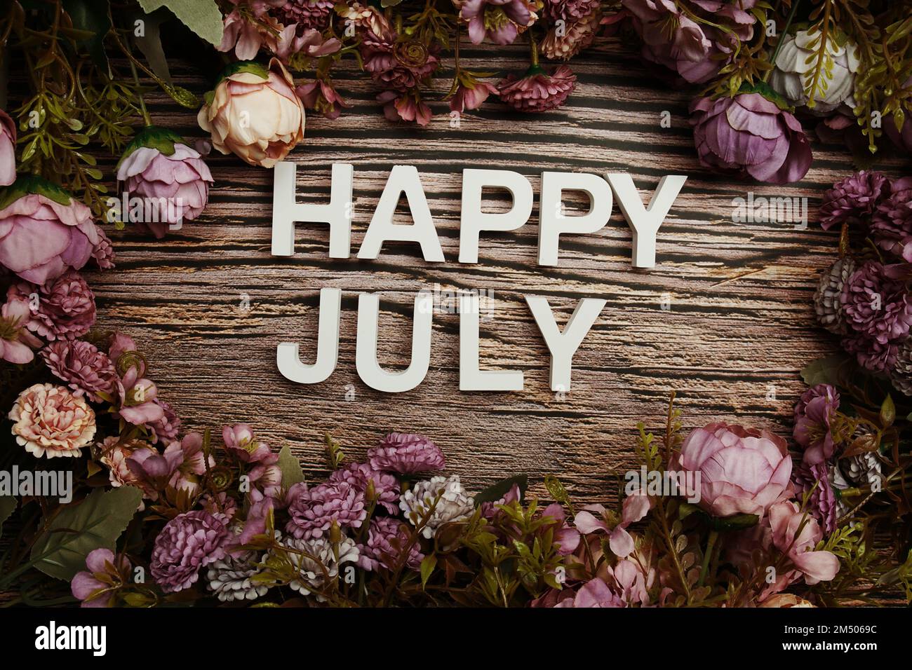 Happy July alphabet letters with flowers frame on wooden background ...