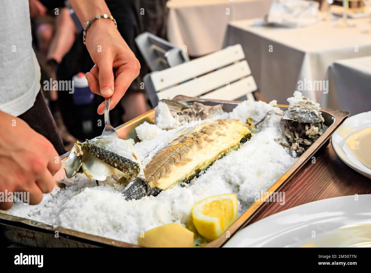 Branzino or Mediterranean sea bass whole roasted in salt fish filleted ...