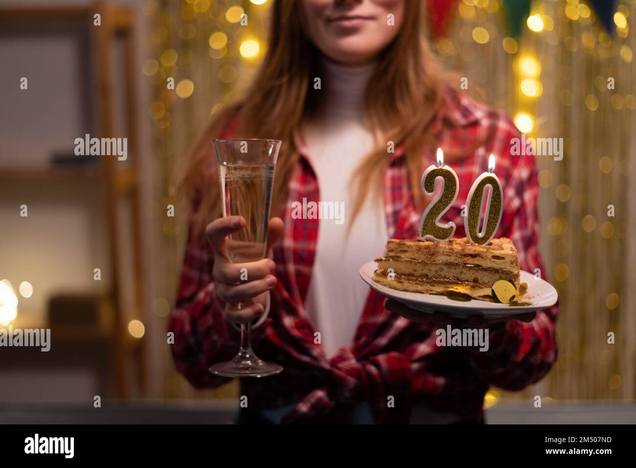 Hands of young woman holding birthday cake with number 20 candles and ...