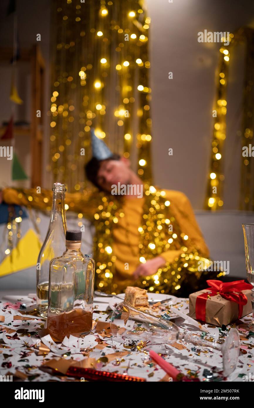 Tired drunk young man after birthday party at home on couch. Copy space ...