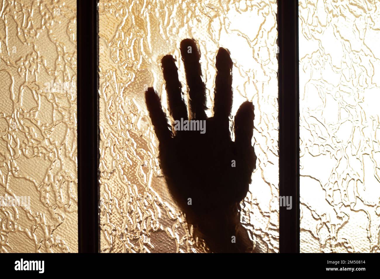 woman's hand in a glass of a door in a dark room Stock Photo - Alamy