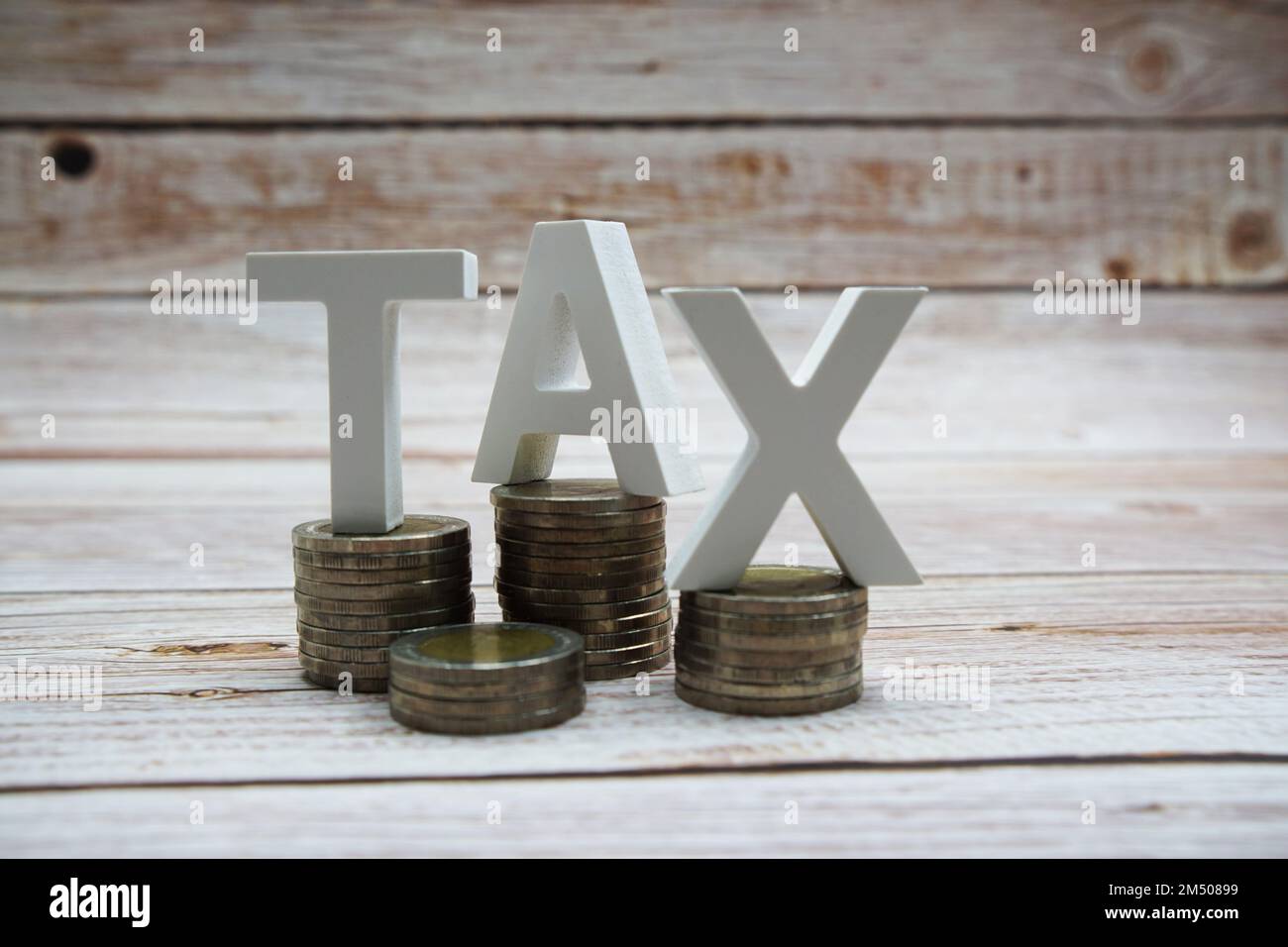TAX alphabet letters with coin stack on wooden background Stock Photo ...
