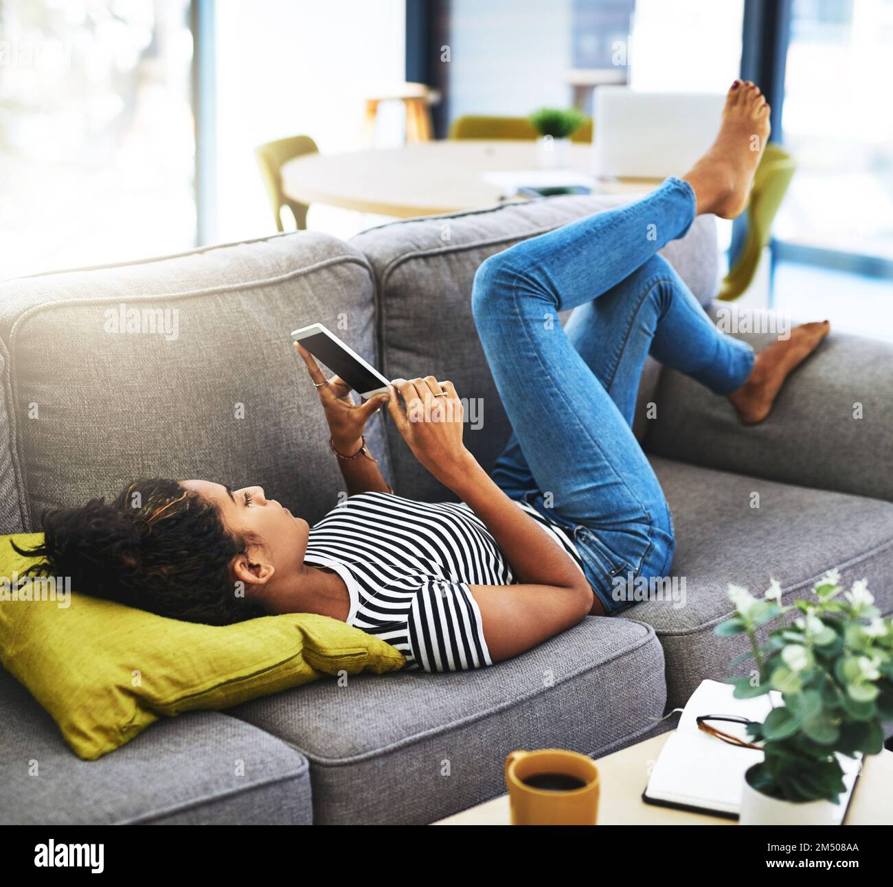 Chilling and chatting. an attractive young woman relaxing at home on ...