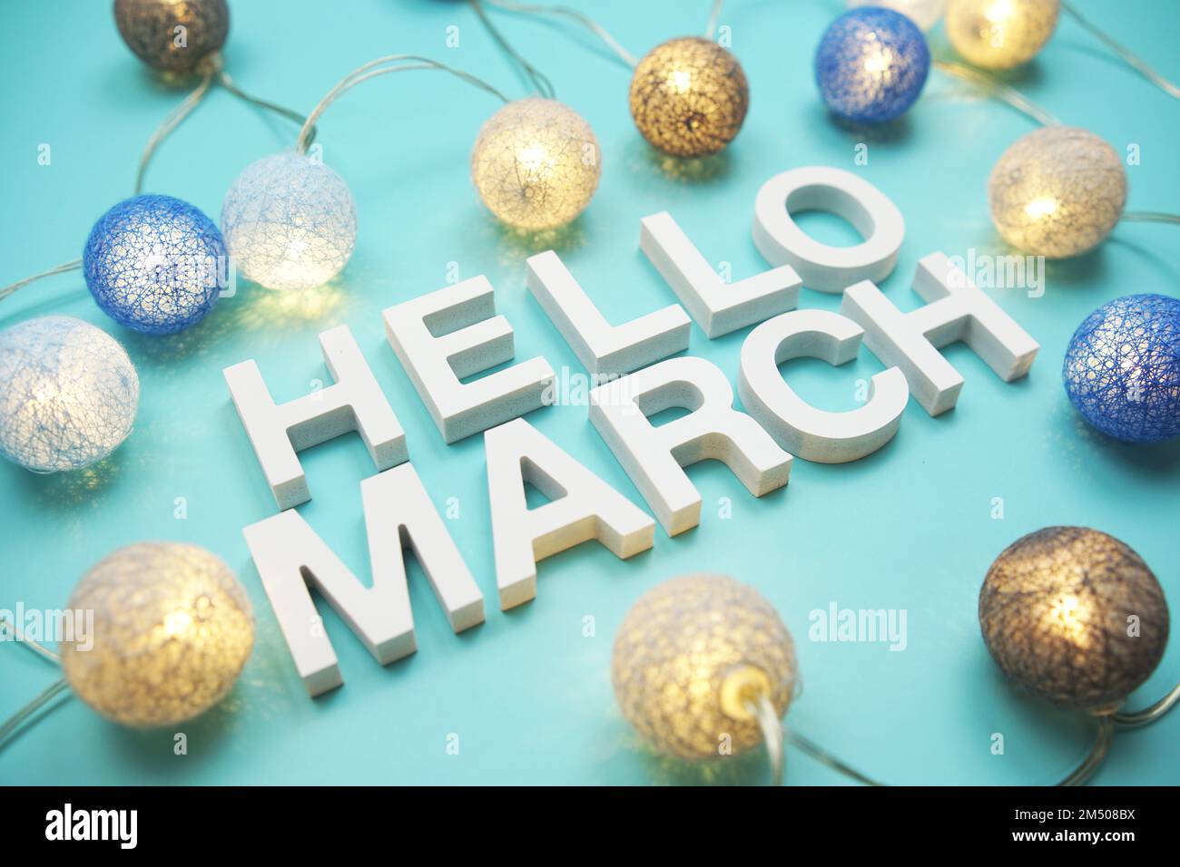 Hello March alphabet letter decorate with LED cotton balls on blue ...