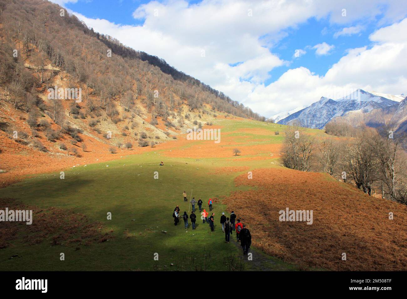 Tourists walking towards the beautiful snowy mountains. Gabala ...